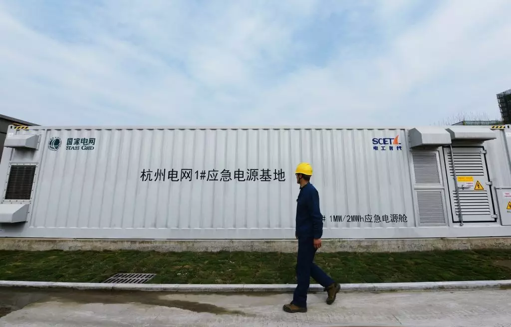 Hangzhou, Kína 2021. április 07. egy férfi nagy teljesítményű lítium-vas-foszfát akkumulátorokat tartalmazó tartály mellett sétál el egy állami hálózatban mozgatható akkumulátor energiatároló rendszerben Hangzhou-ban Kelet-Kínában039s Zhejiang tartomány, szerda, 2021. április 7., a 20 megawattos energiaállomás egyike a következő év tervei 039-es ázsiai játékok fotója a jövőbeli kínai közzététel a Getty Images segítségével